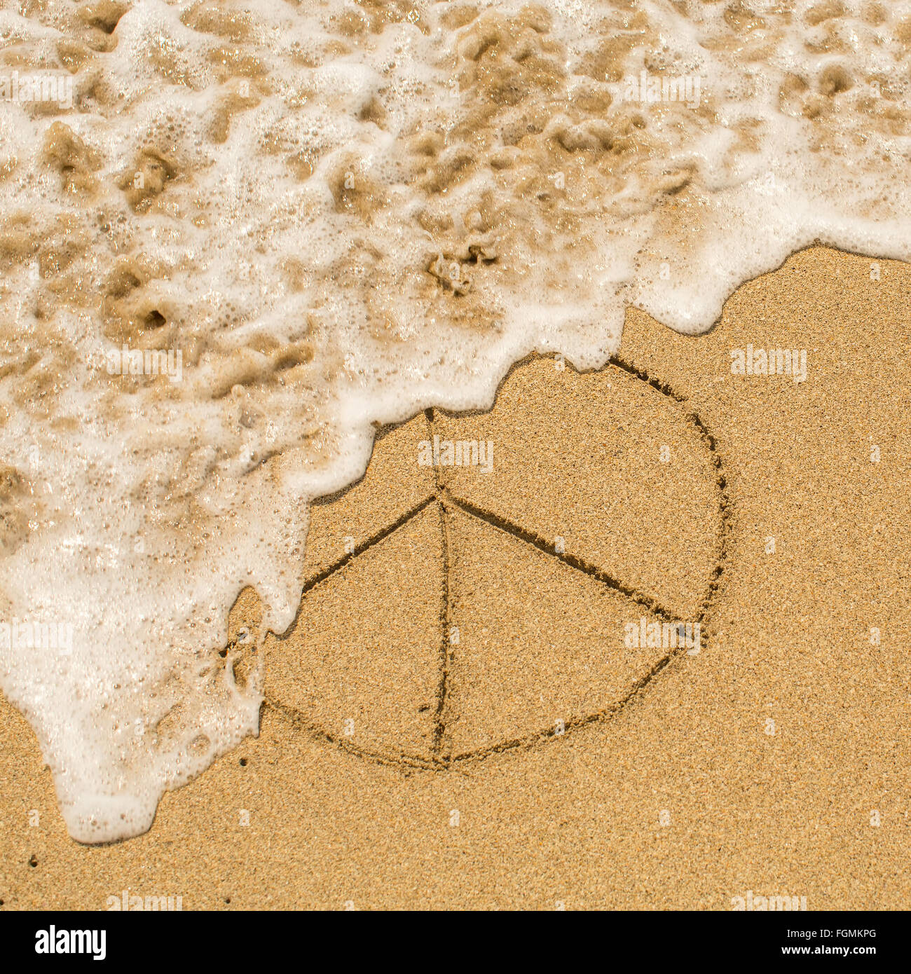 Peace sign (pacific) drawn on the sand of a beach with the soft wave ...