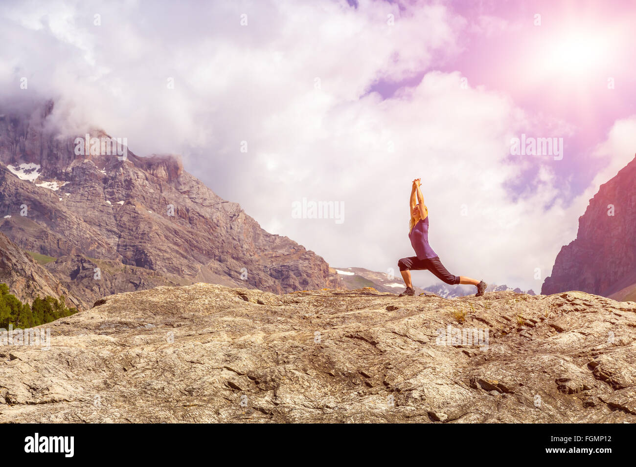 Young woman body on top of stone rock stretching body Stock Photo - Alamy