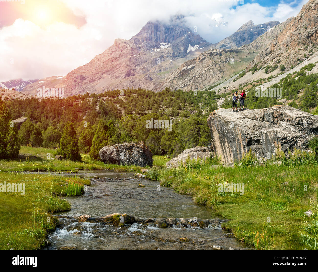 Mountain Stream and Female Hikers on Rock Stock Photo - Alamy