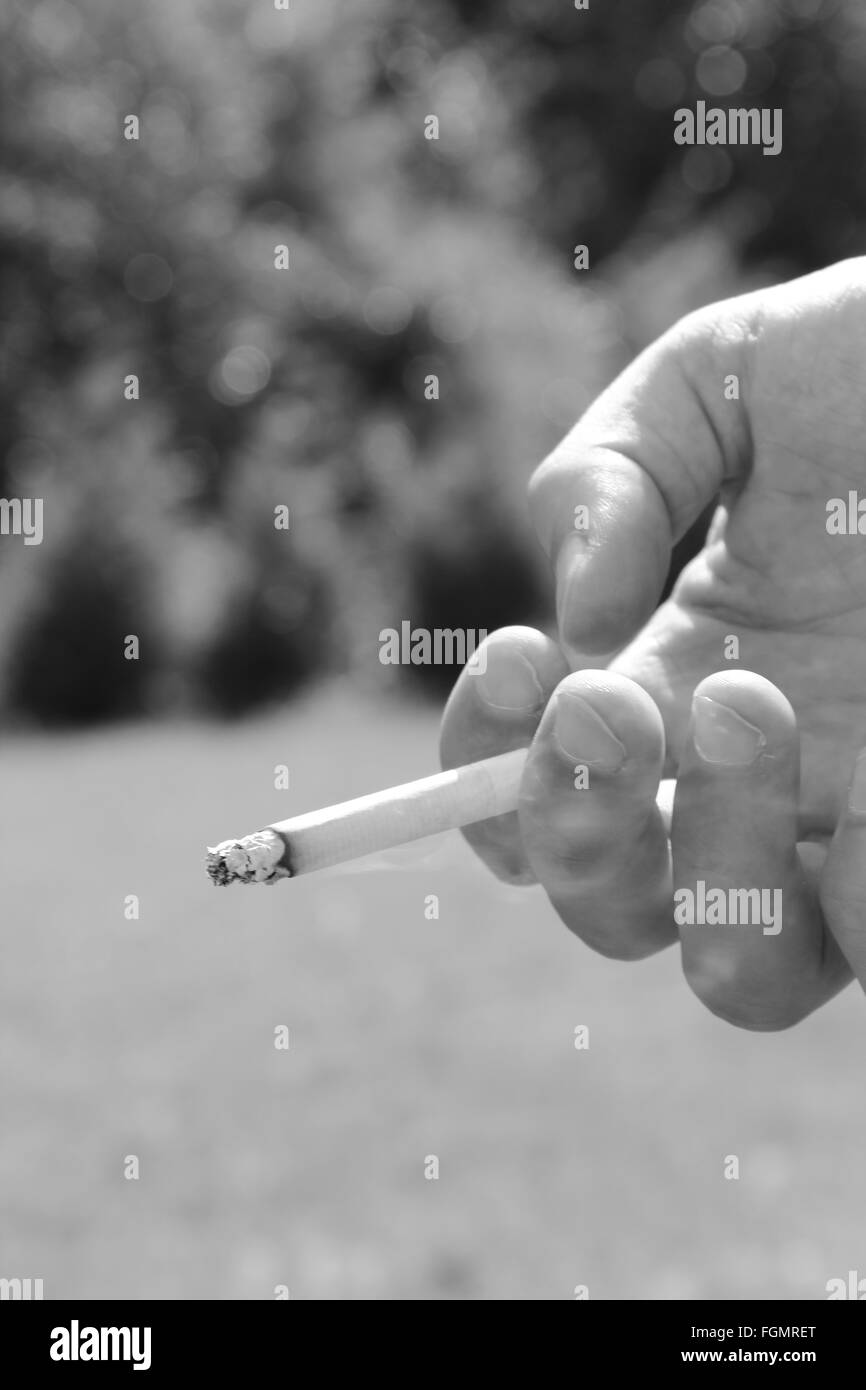 Cigarette in hand Black and White Stock Photos & Images - Alamy