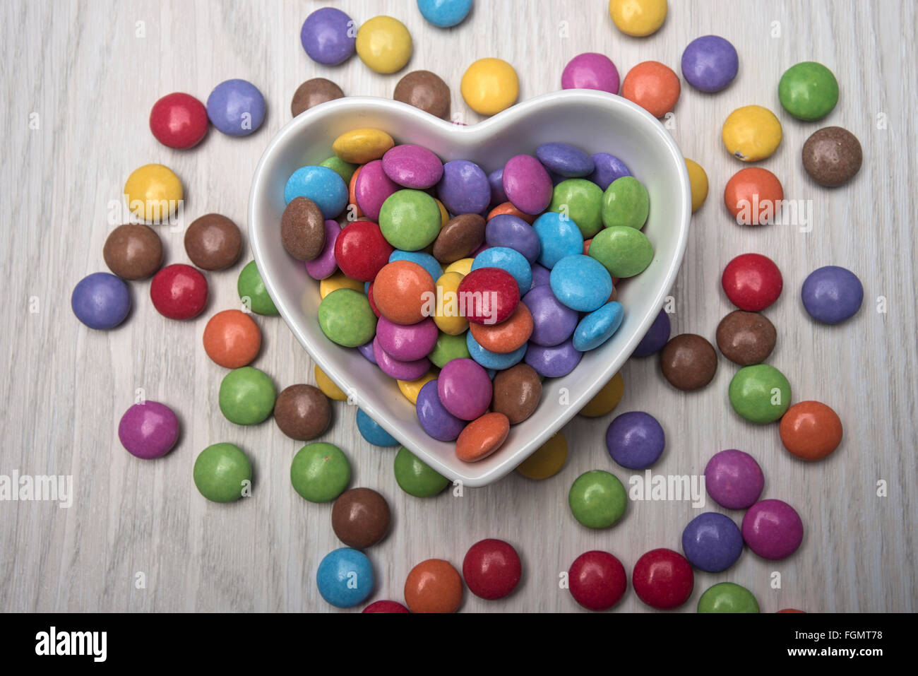 Colourful chocolate Smarties in a heart shaped white dish, bowl Stock ...