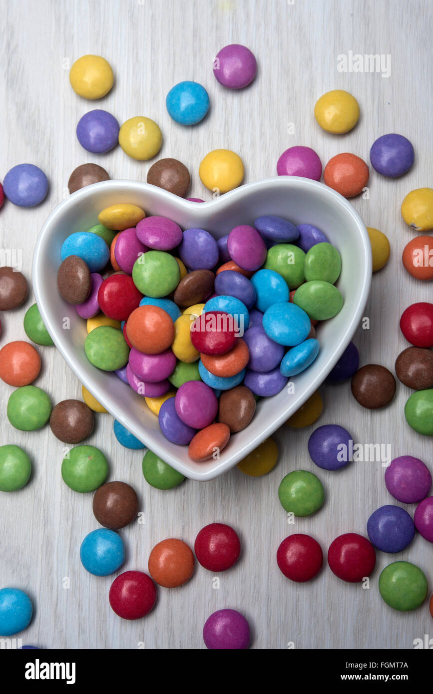 Colourful chocolate Smarties in a heart shaped white dish, bowl Stock ...