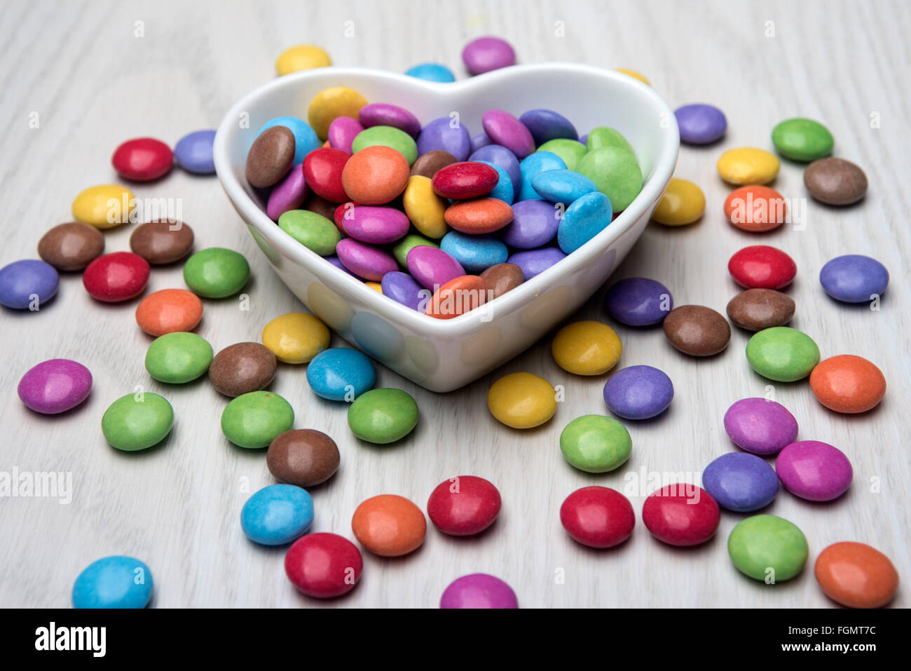 Colourful chocolate Smarties in a heart shaped white dish, bowl Stock ...