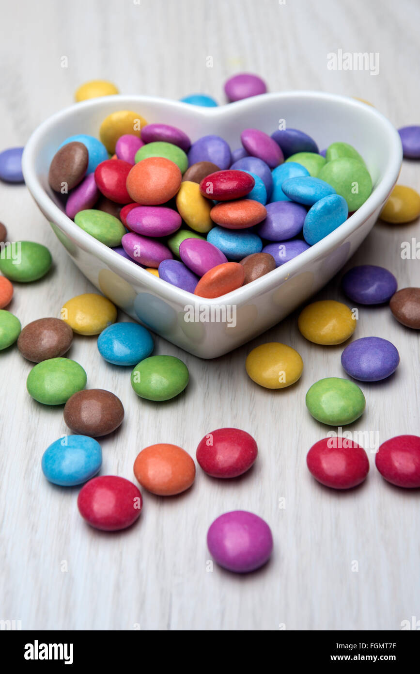 Colourful chocolate Smarties in a heart shaped white dish , bowl Stock ...