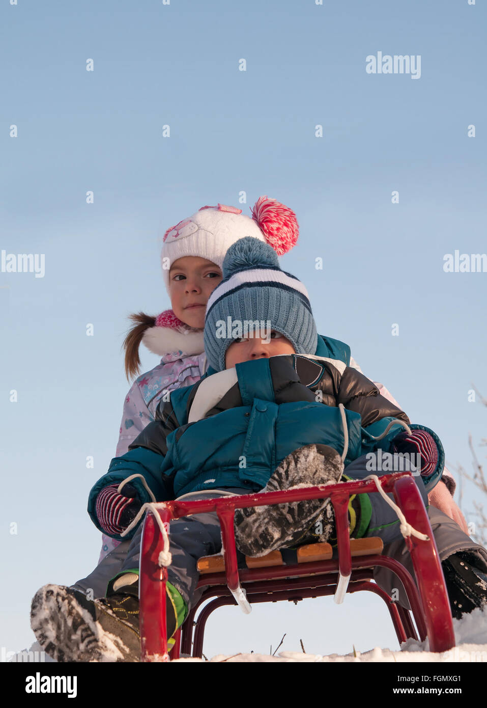 two kids sliding with sledding in the snow Stock Photo - Alamy