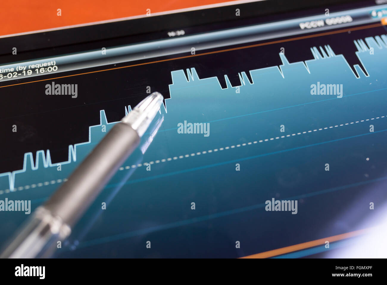 Tablet with stock graph on a wood table Stock Photo - Alamy
