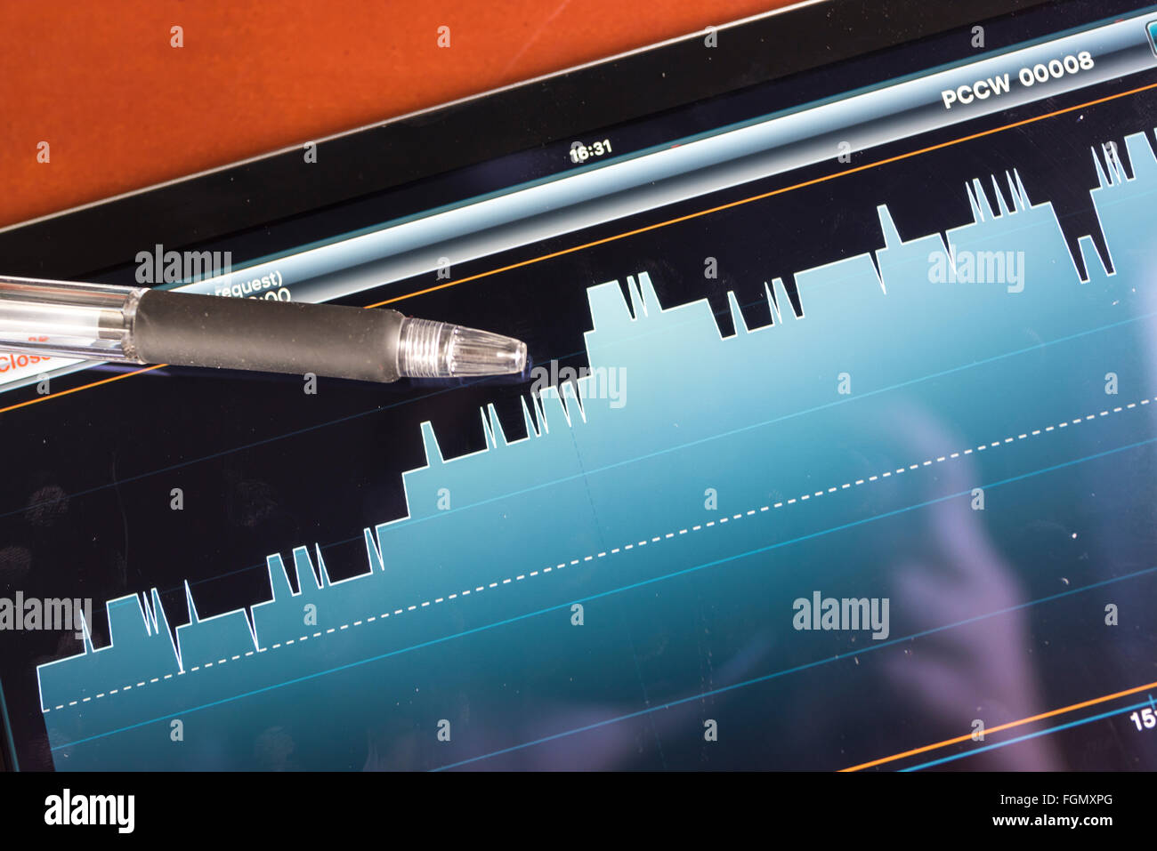 Tablet with stock graph on a wood table Stock Photo - Alamy