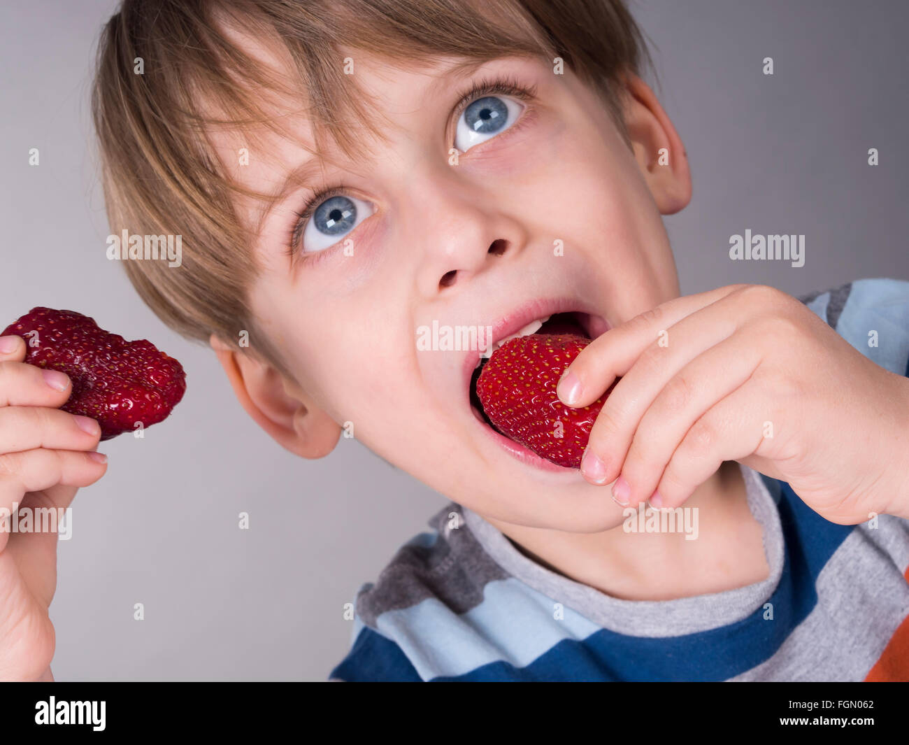 boy eating strawberries Stock Photo - Alamy