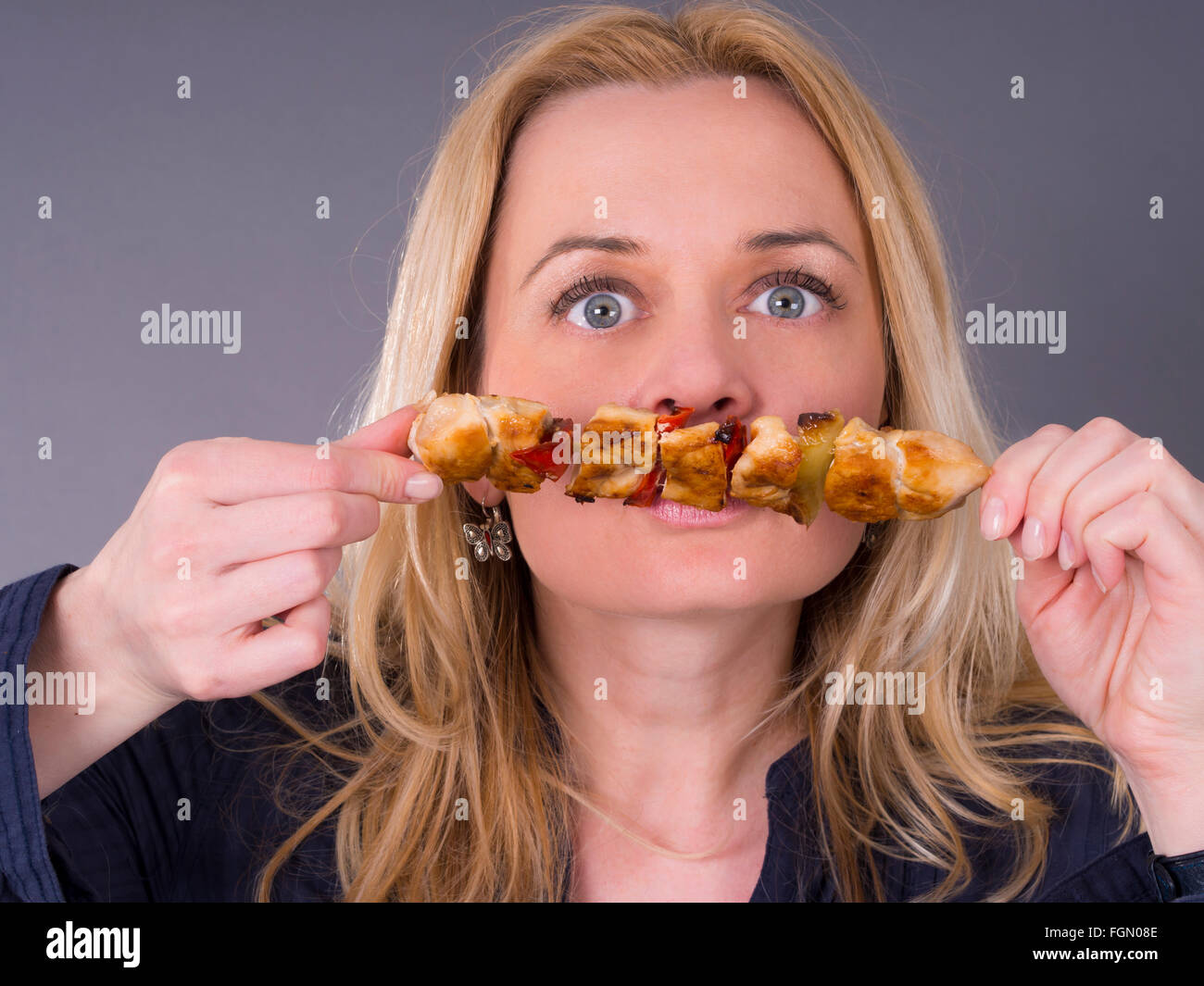 blond woman smelling grilled meat Stock Photo - Alamy