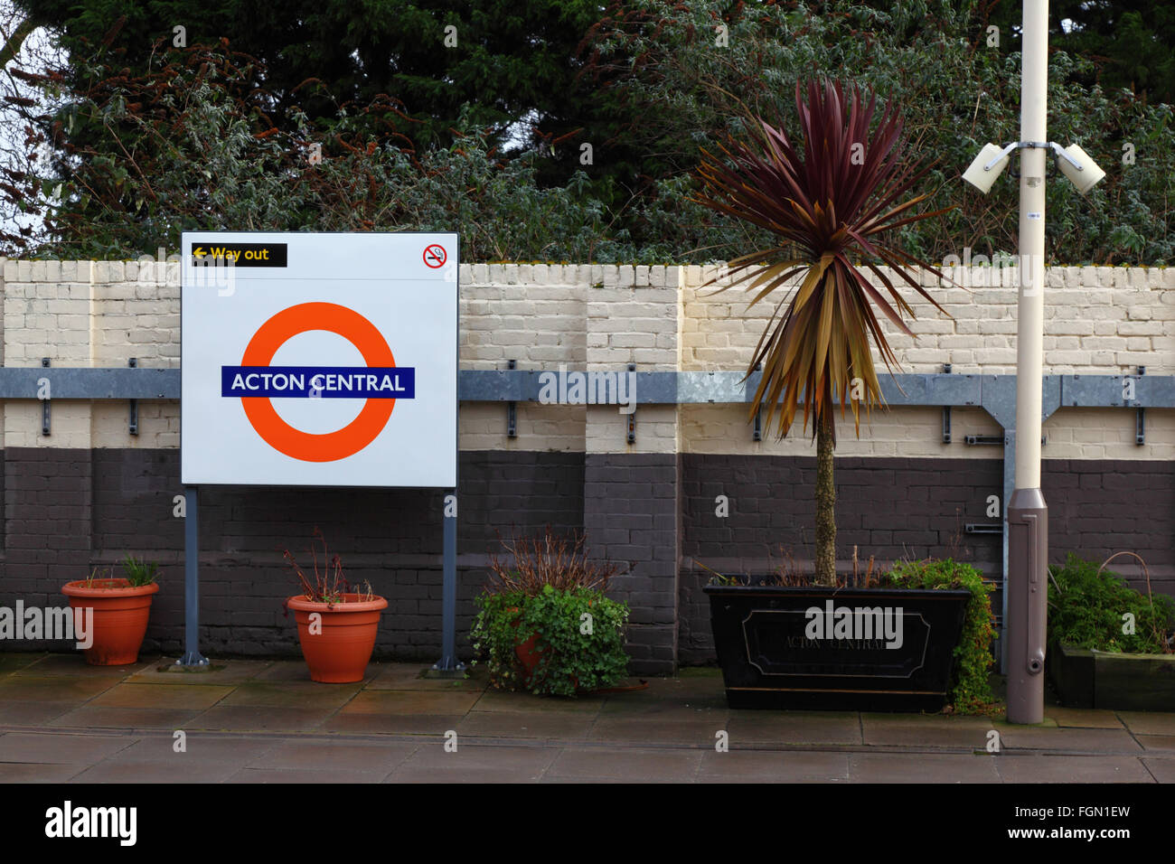 Pot plants and sign on platform at Acton Central Overground station ...