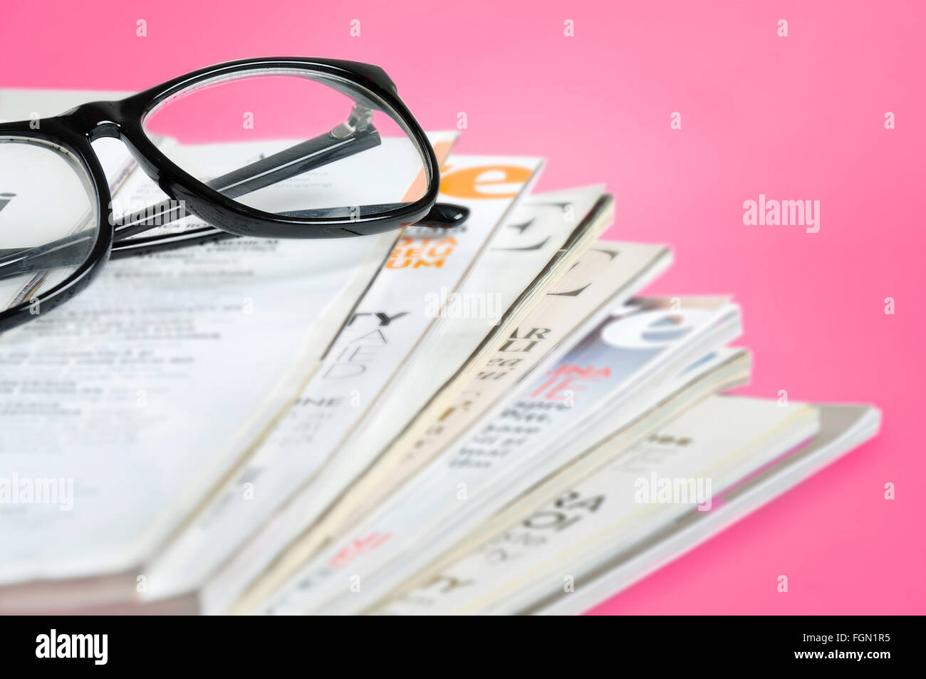 Stacked magazines on pink background Stock Photo - Alamy