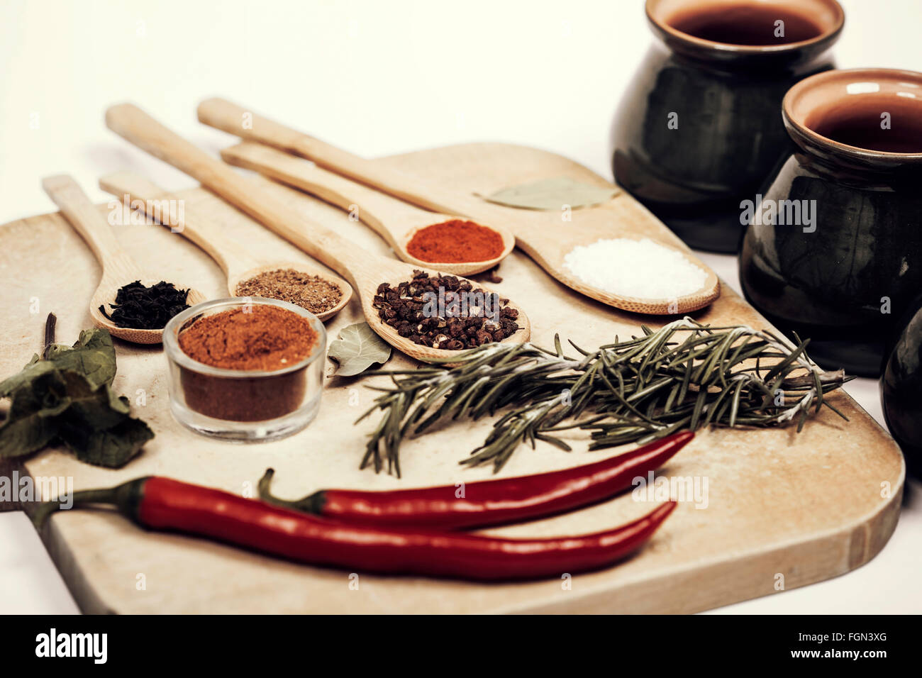 Various colorful spices on kitchen spoons over grunge wooden table ...