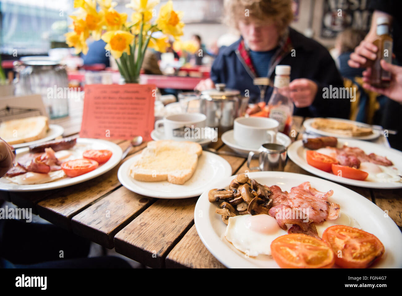 Plates of tasty cooked traditional English breakfast in a hip cafe with ...