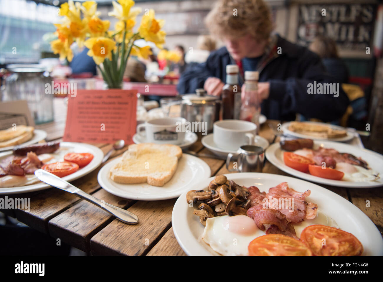 Plates of tasty cooked traditional English breakfast in a hip cafe with ...