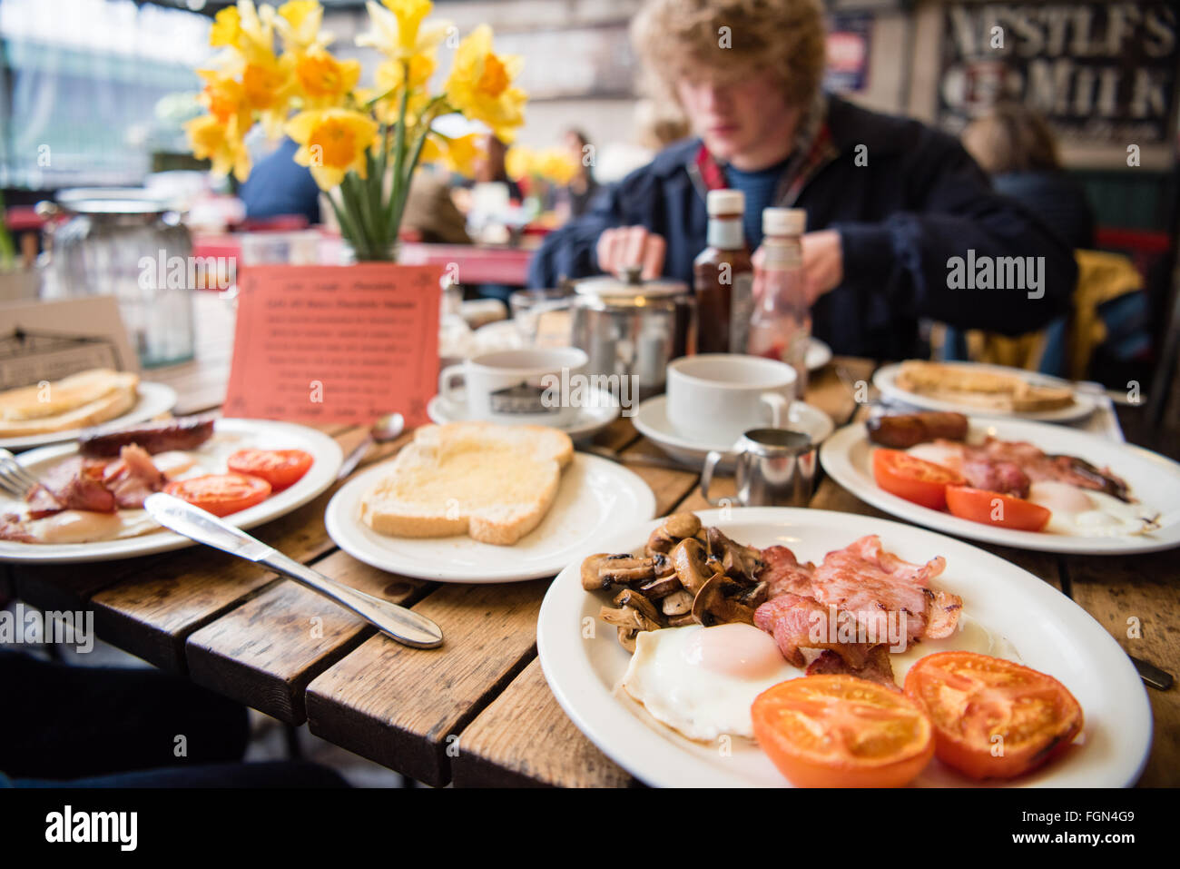 Plates of tasty cooked traditional English breakfast in a hip cafe with ...