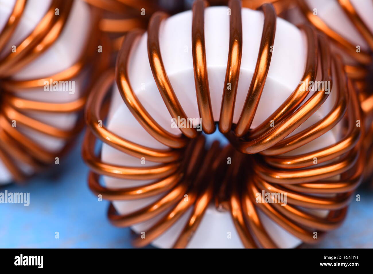 Macro of a copper coils on blue background Stock Photo - Alamy