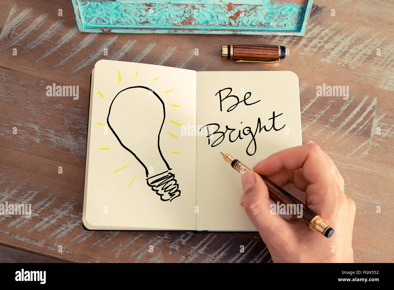 Retro effect and toned image of a woman hand drawing a light bulb next ...