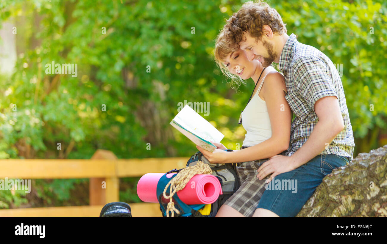 Man and woman tourists backpackers reading map on trip while resting ...