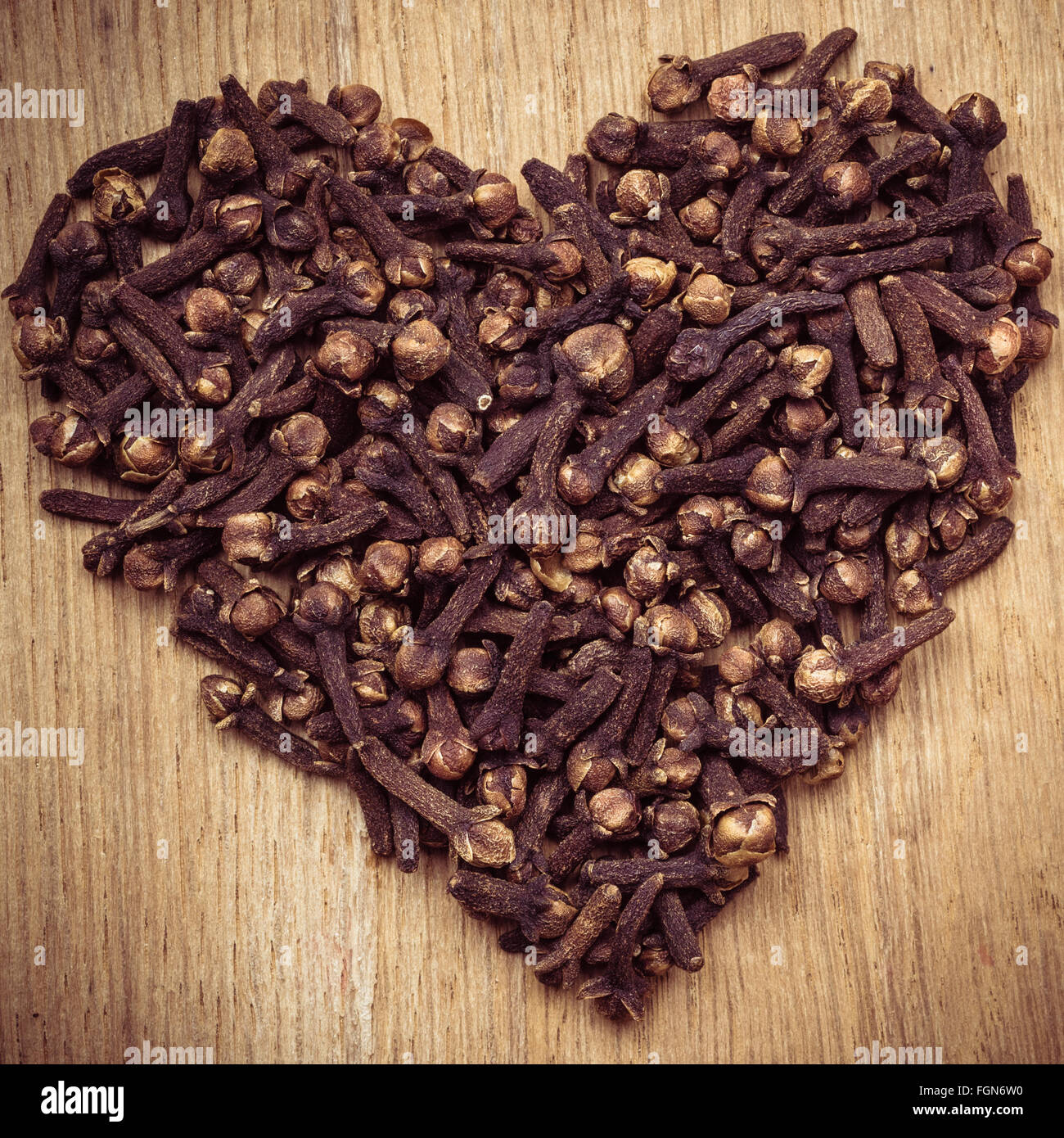 Heart form made from spice cloves on wooden background Stock Photo - Alamy
