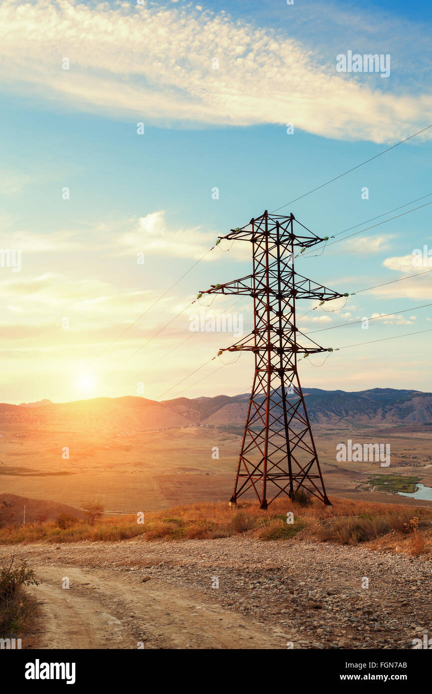 High voltage tower in mountains on the background of colorful sky at ...