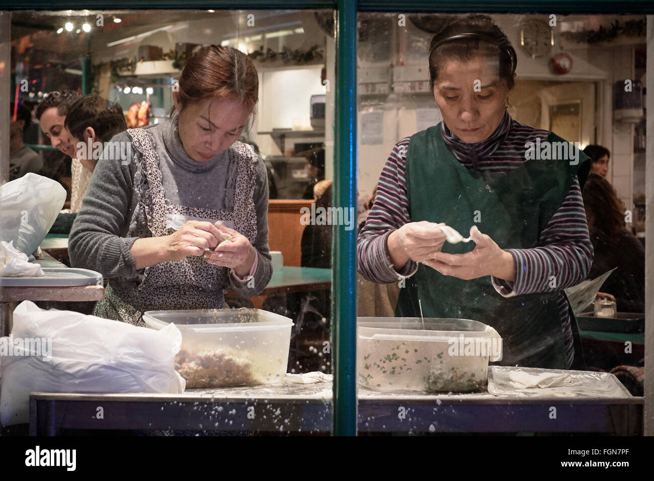 Two women making Chinese dumplings in the window of a restaurant Stock ...