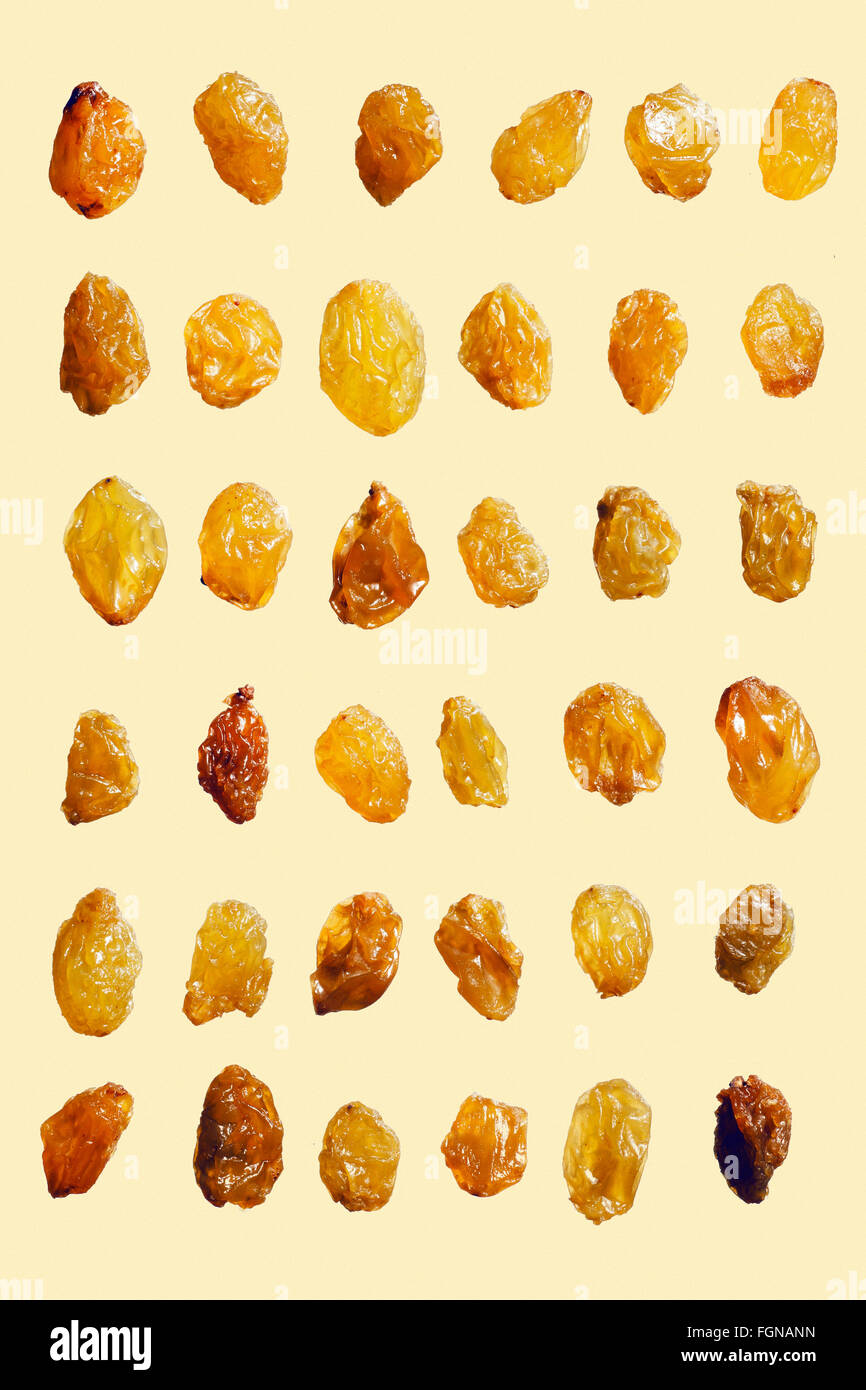 Golden raisins on yellow background Stock Photo - Alamy