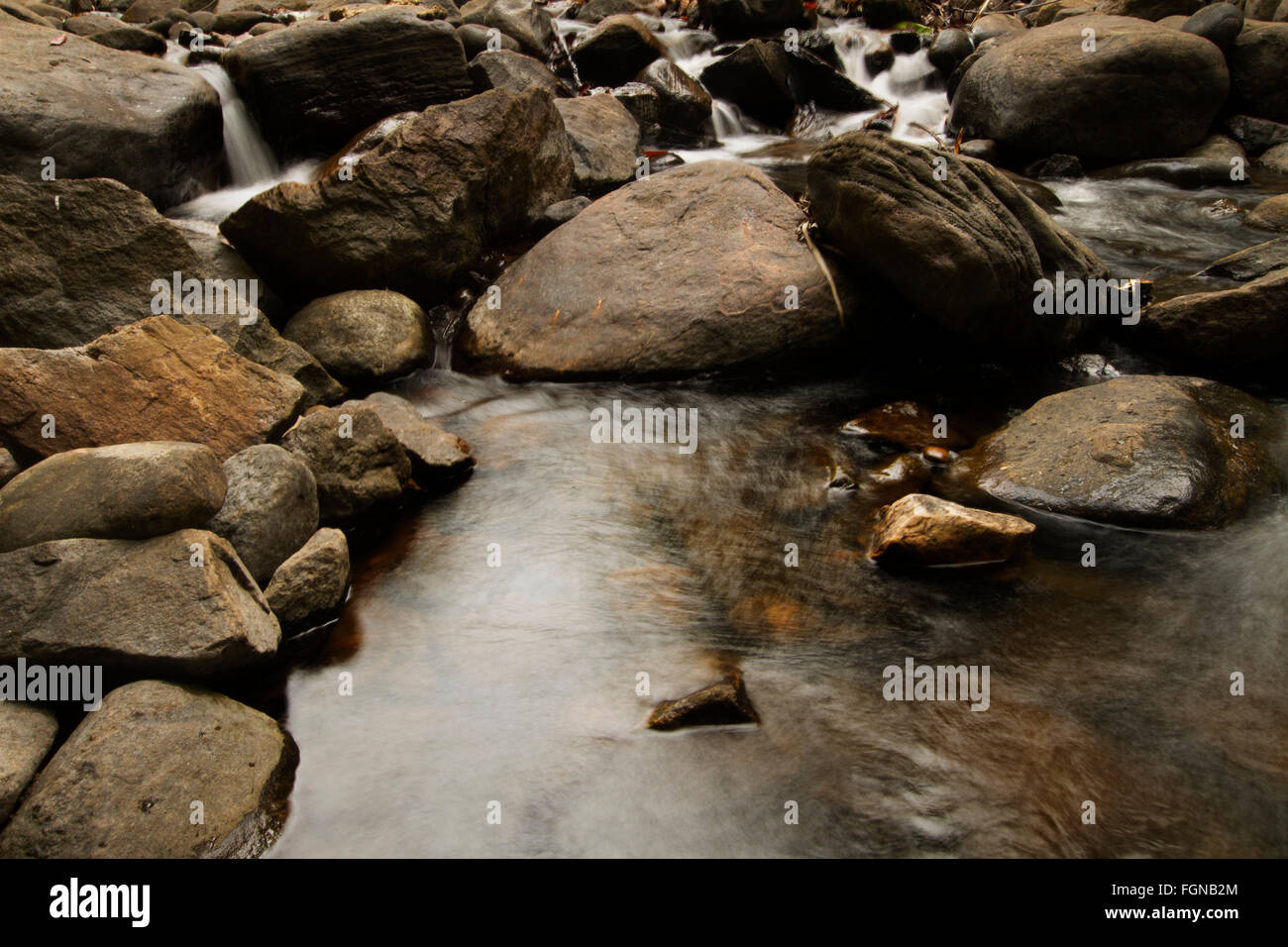 brown natural wet rocks in river water background Stock Photo - Alamy