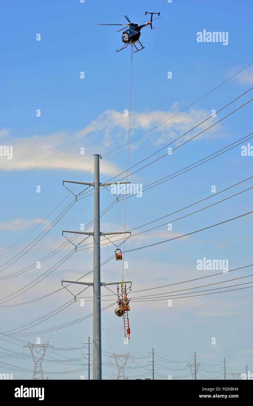Electrical tower workers suspended from a helicopter Stock Photo - Alamy