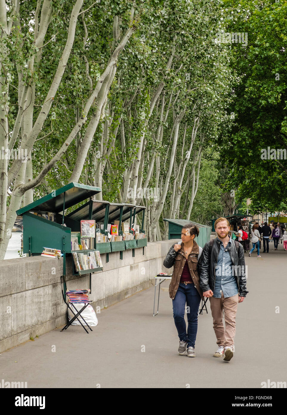 A couple walks by book-stands that line a Paris street next to the ...
