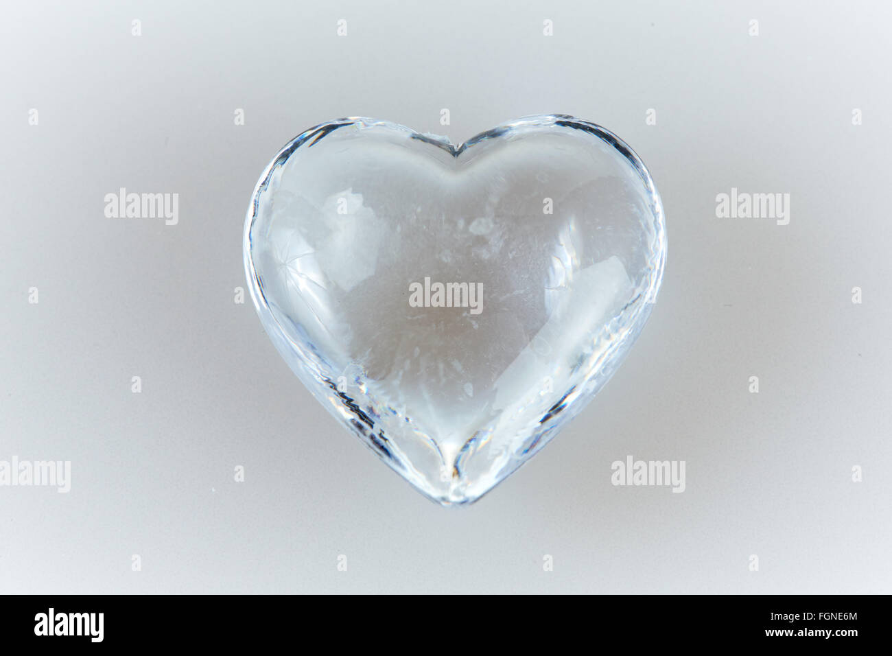 Clear colorless diamond heart lying in a white glass table Stock Photo ...