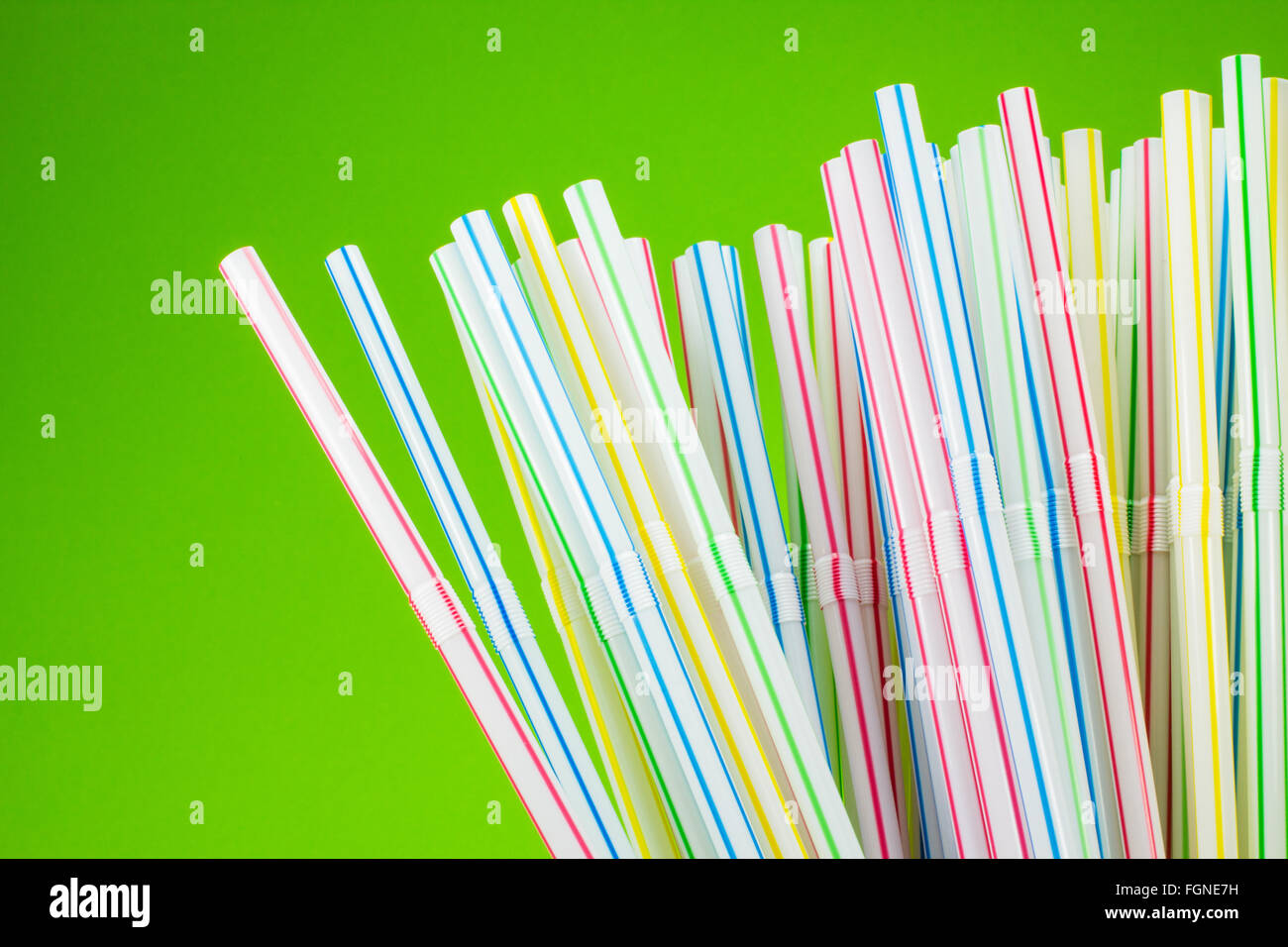 Colored drinking straws on green background Stock Photo - Alamy