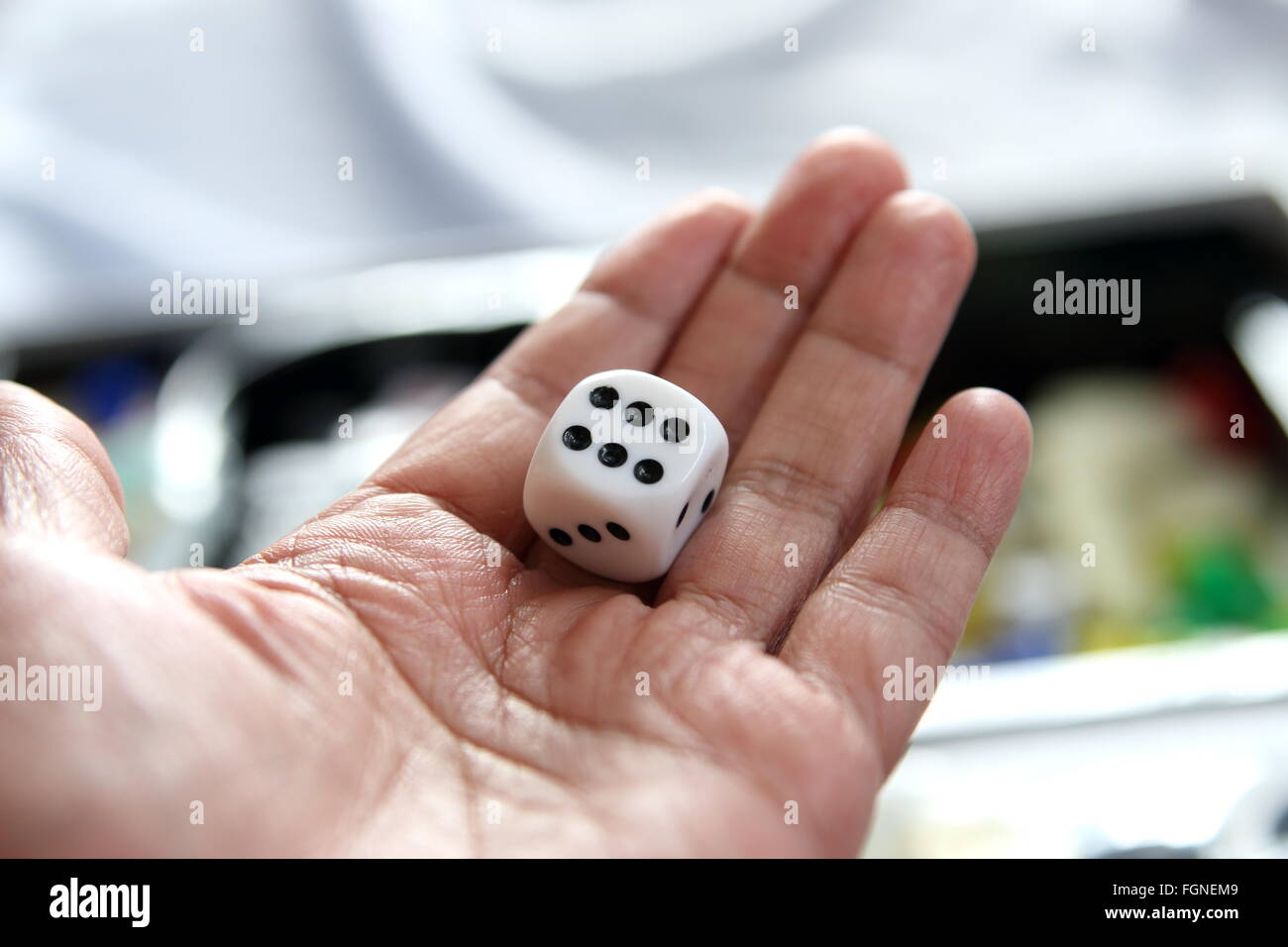 Left hand holding a dice Stock Photo - Alamy