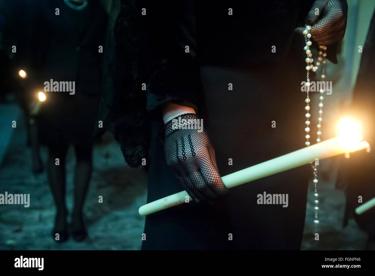 A girl carries a candle and rosary during procession of Christ the sea ...