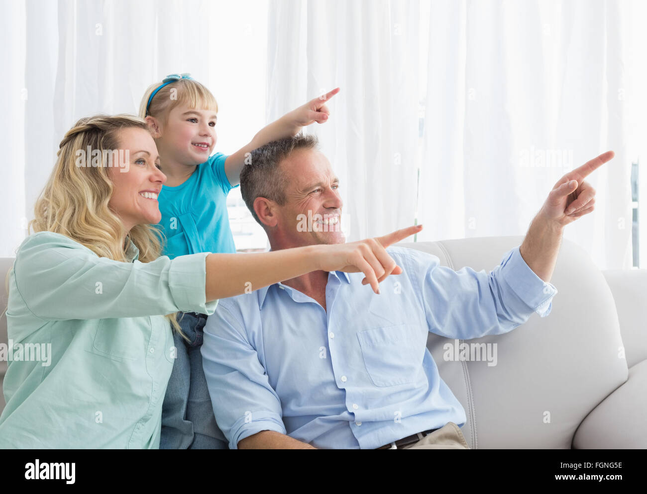 Nice parents and daughter pointing something Stock Photo - Alamy
