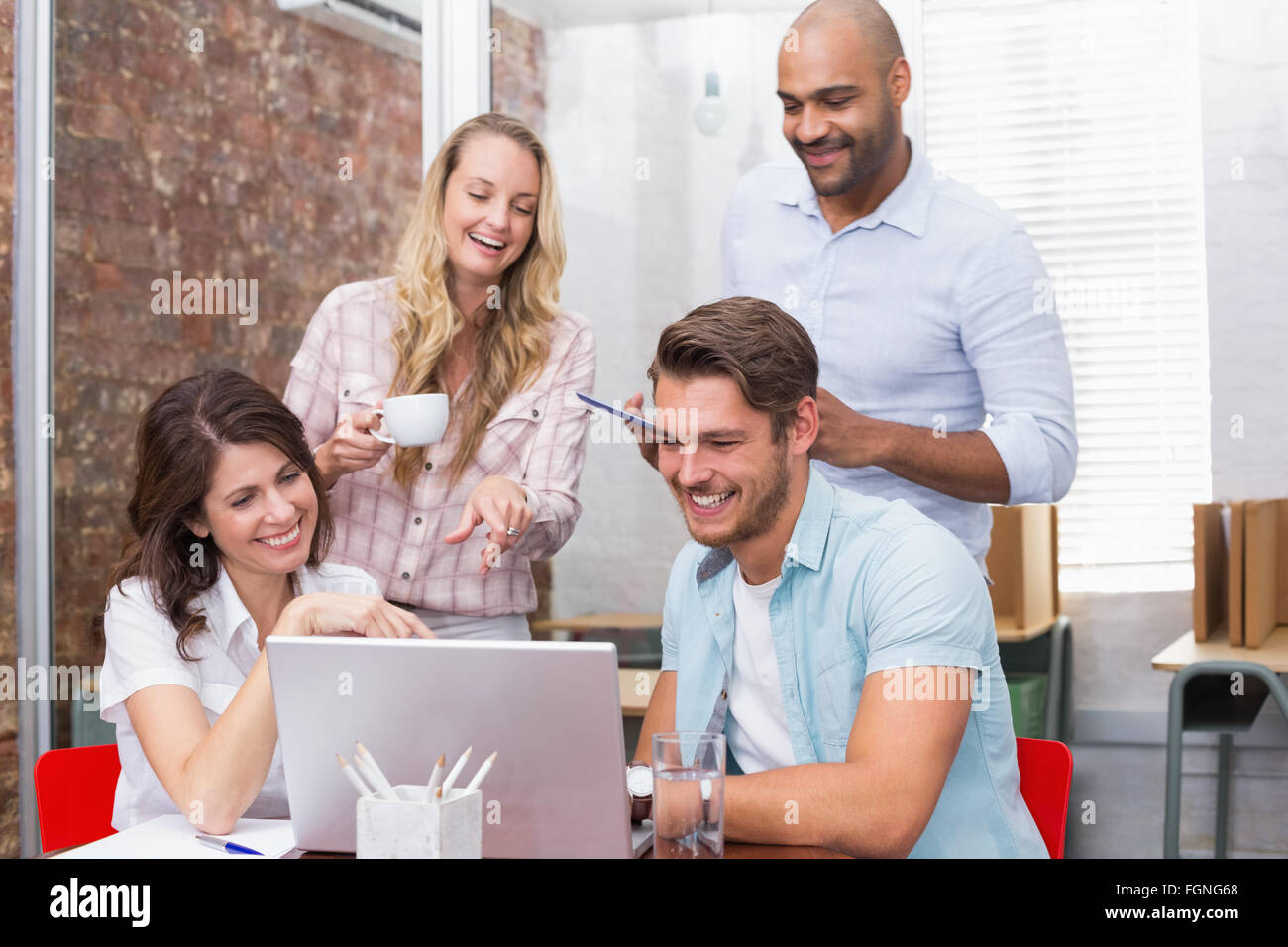 Business team laughing together in front of the laptop Stock Photo - Alamy