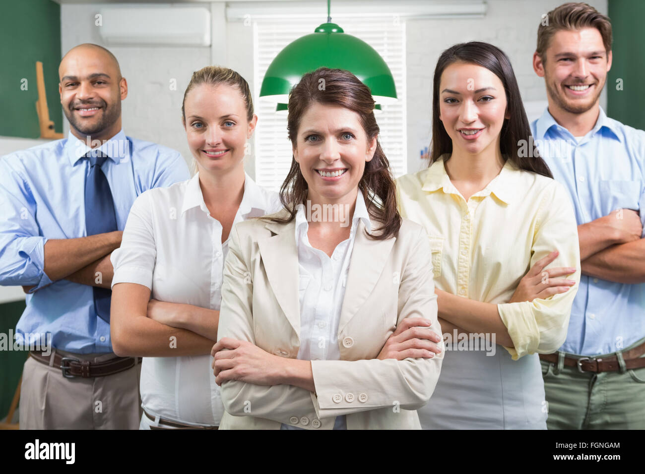 Leader and staff standing smiling with arms crossed Stock Photo - Alamy