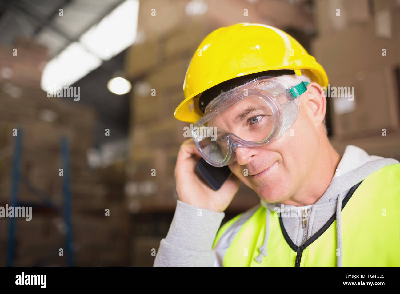 Worker using mobile phone in warehouse Stock Photo - Alamy