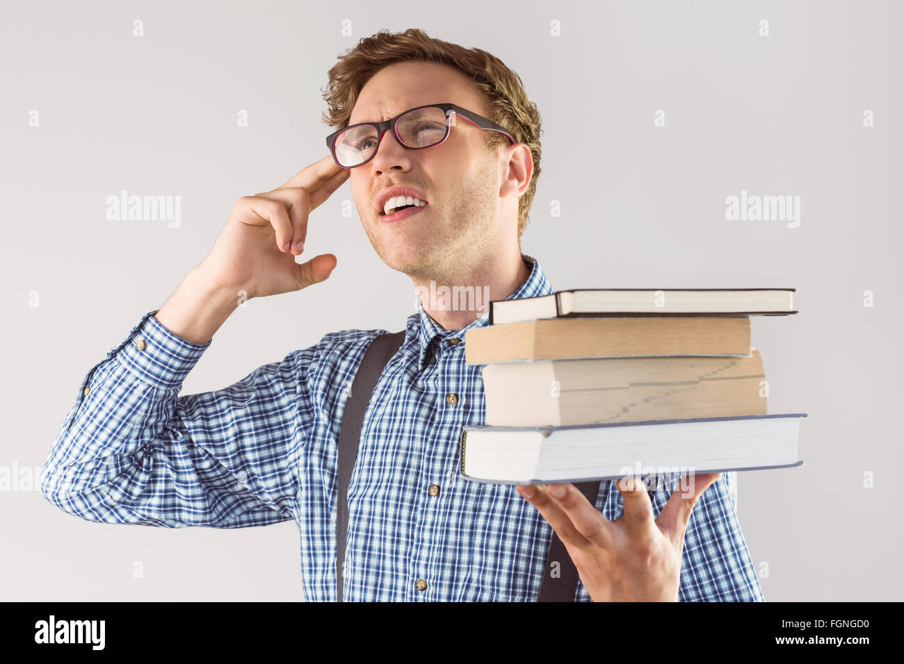 Geeky student holding a pile of books Stock Photo - Alamy