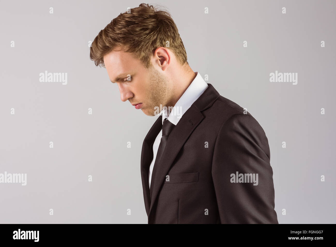 Young handsome businessman looking down Stock Photo - Alamy