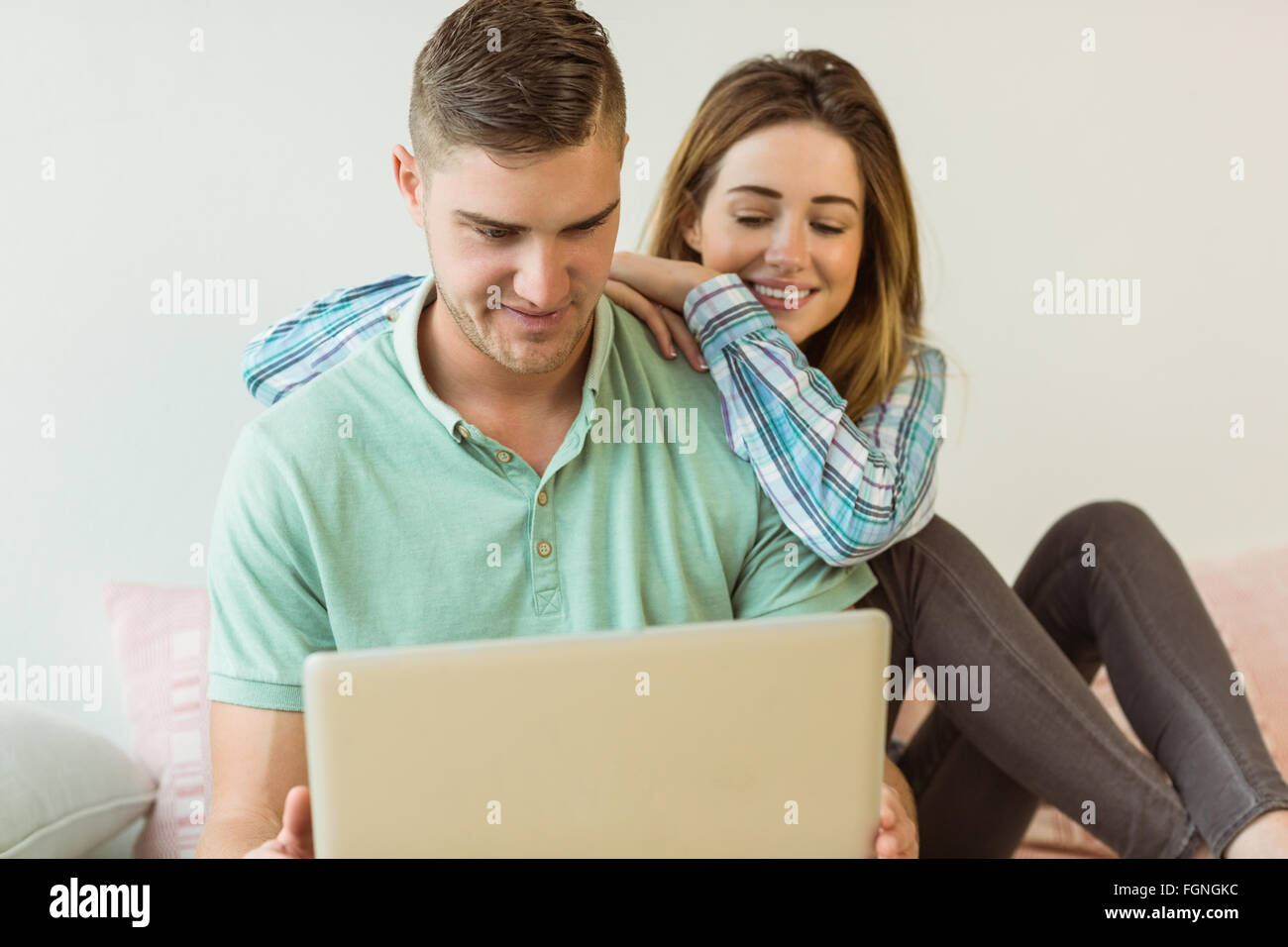 Cute couple relaxing on couch with laptop Stock Photo - Alamy