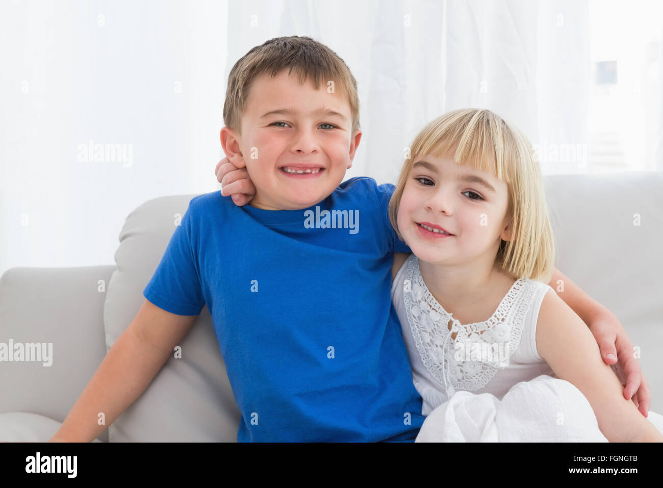 Happy siblings smiling at camera together Stock Photo - Alamy