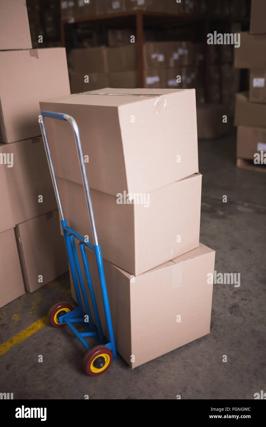Boxes on trolley in warehouse Stock Photo - Alamy