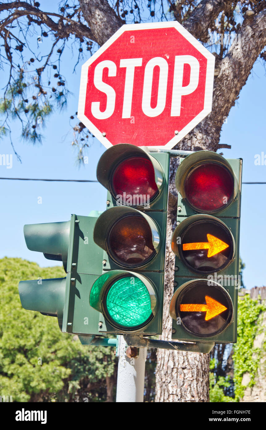 Road sign "stop" and traffic lights at the crossroads on sunny day with ...