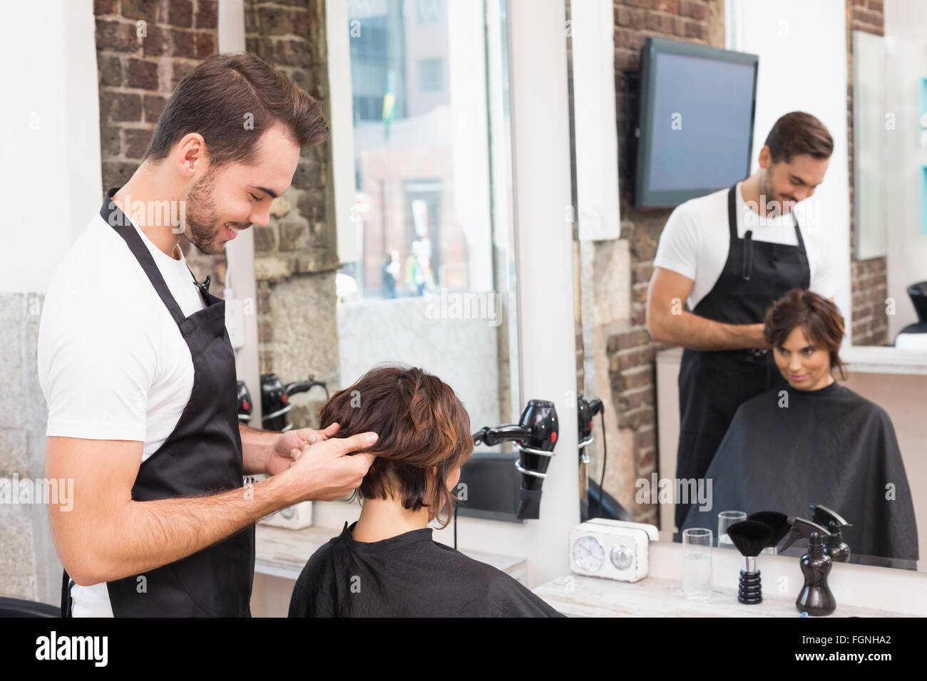 Handsome hair stylist with client Stock Photo - Alamy