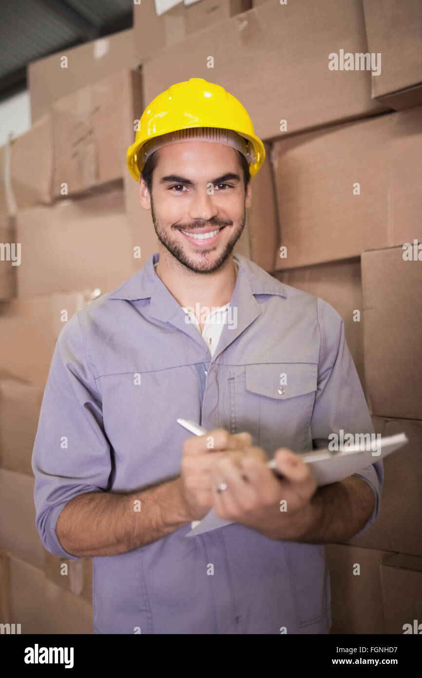 Worker with clipboard in warehouse Stock Photo - Alamy