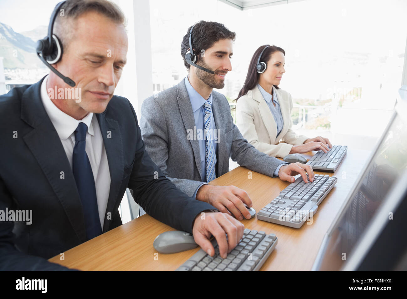 Smiling business team working hard Stock Photo - Alamy