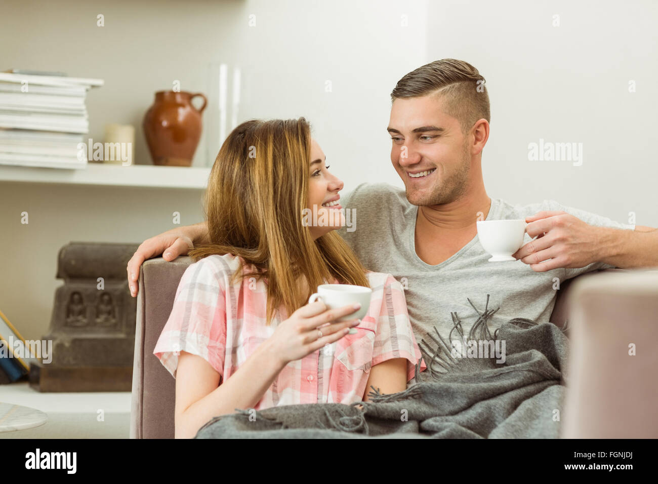 Cute couple relaxing on couch with coffee Stock Photo - Alamy