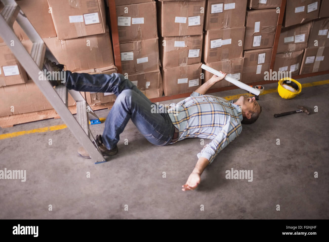 Worker lying on the floor in warehouse Stock Photo - Alamy