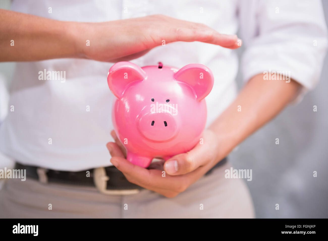 Businessman standing holding piggy hi-res stock photography and images ...