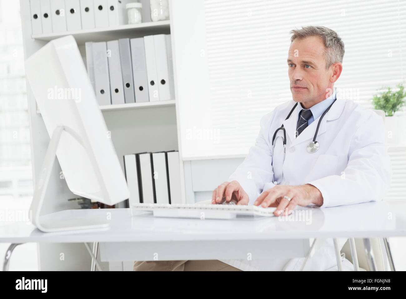 Doctor using his work computer Stock Photo - Alamy